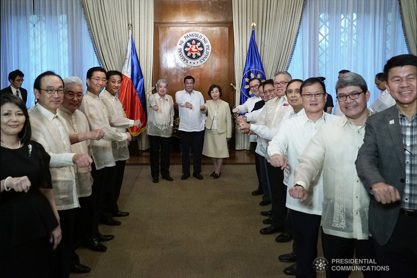 In photo: President Duterte does his signature pose with members of ...